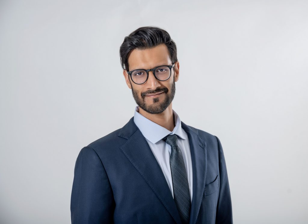 Dr. Baig Navy suit grey background - CORE Orthopedics